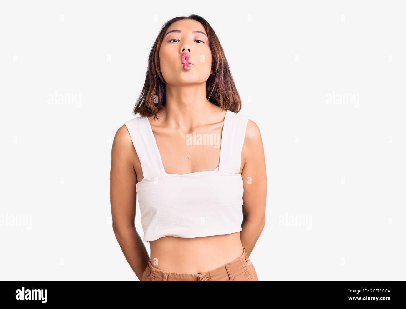 Young beautiful chinese girl wearing casual clothes making fish face ...