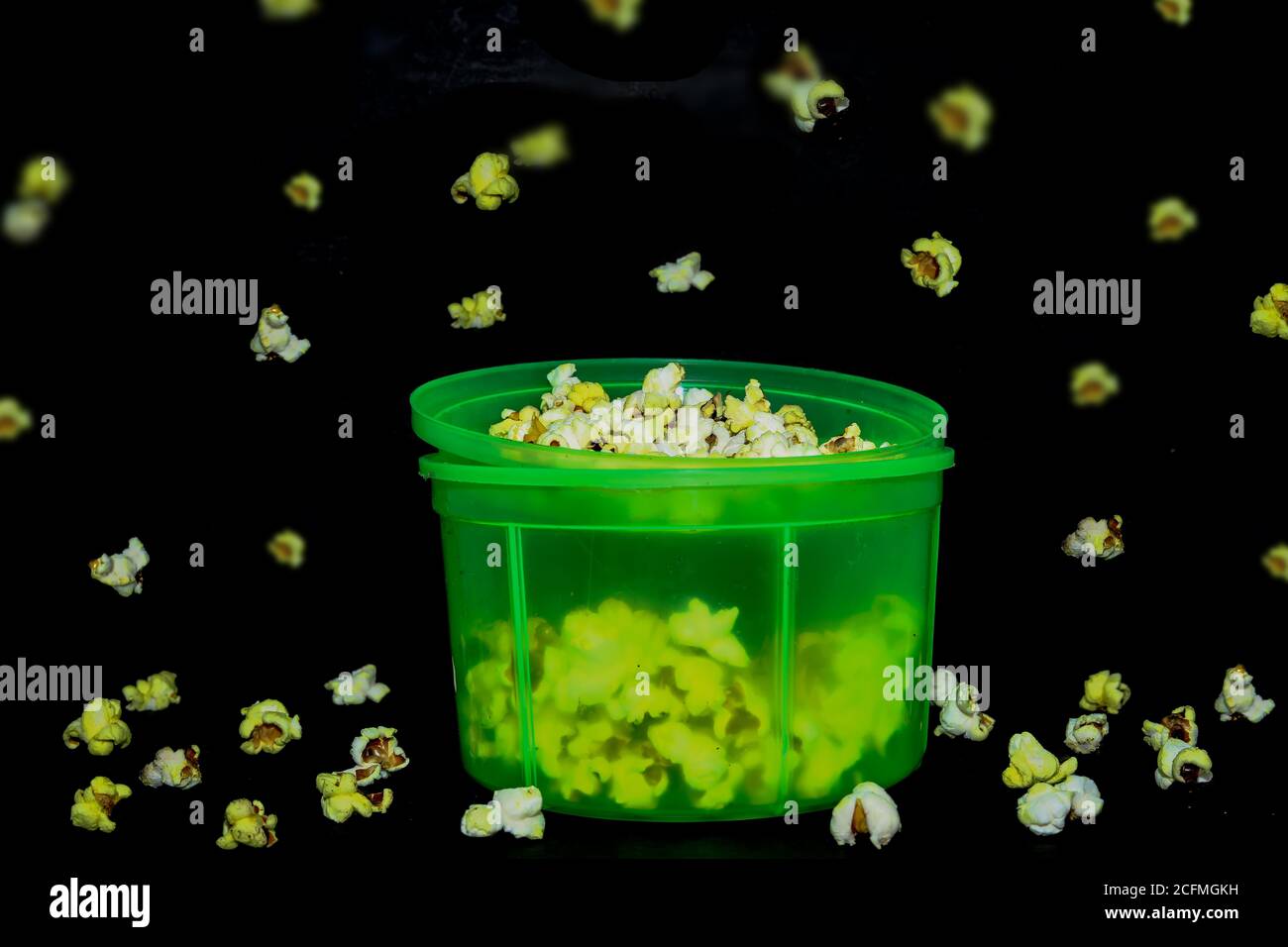Popcorn bucket with falling popcorn and black backgrounds Stock Photo ...