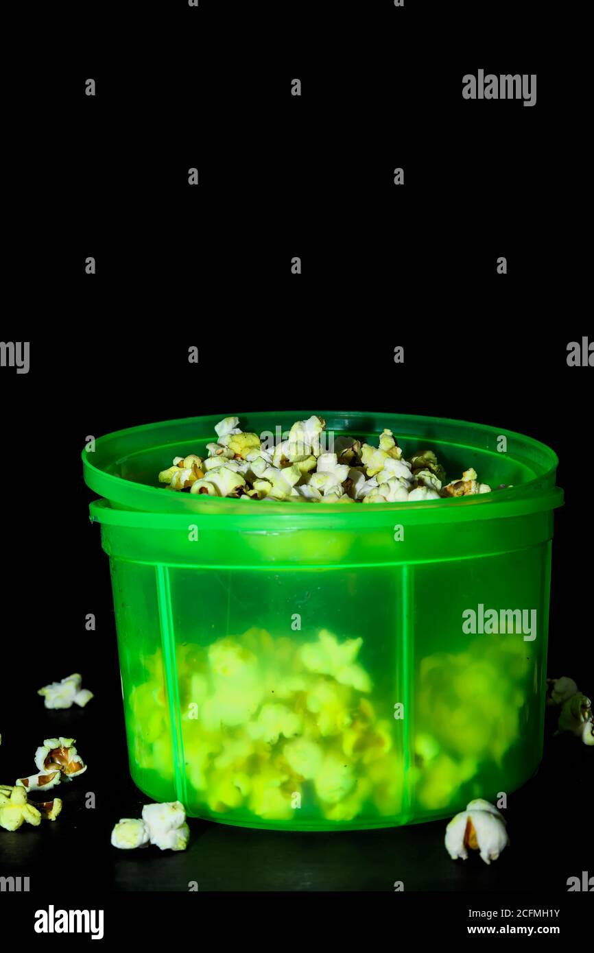 Green box with popcorn on black backgrounds Stock Photo - Alamy