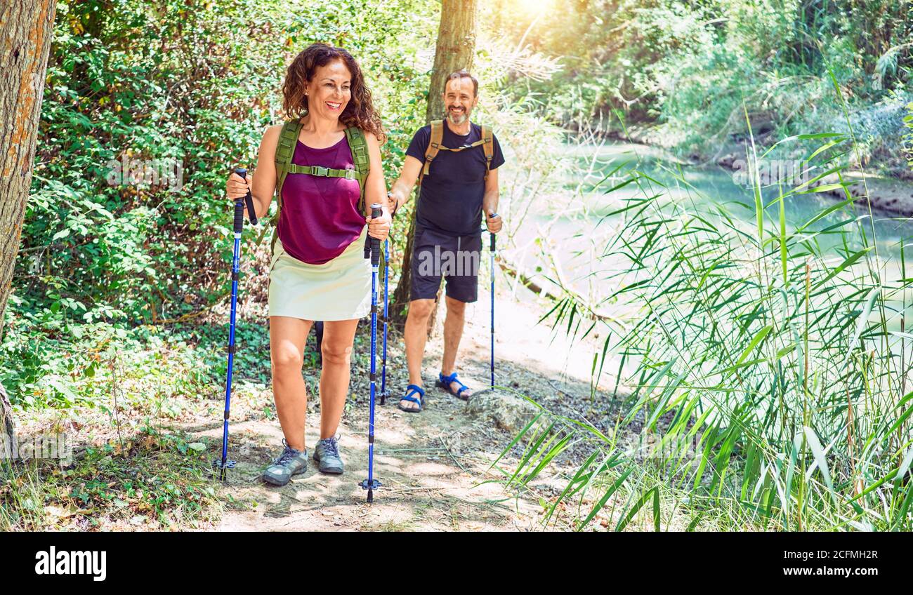 Beautiful couple of hiker wearing backpack smiling happy. Standing with ...