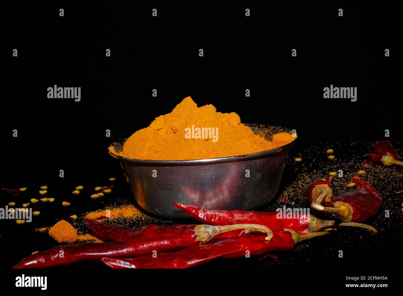 Red Chilly or Mirchi with Powder in a bowl over black background Stock ...