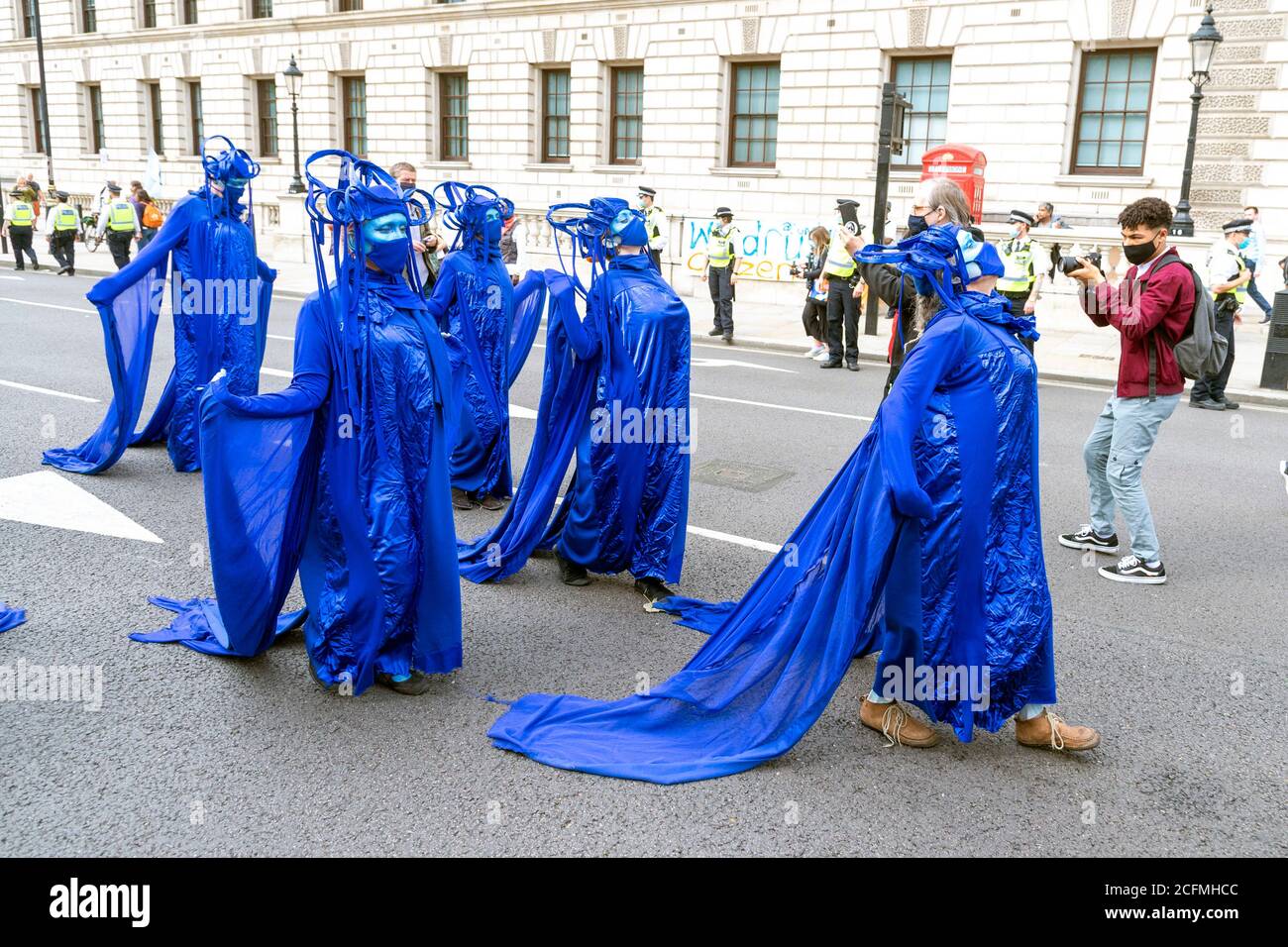 Protesters wear blue outfits to represent the ocean during the ...
