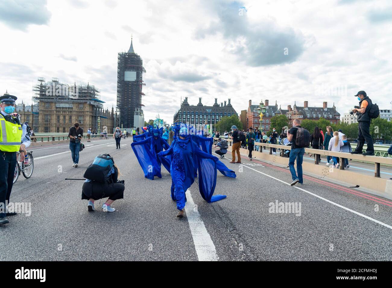 Protesters wear blue outfits to represent the ocean during the ...