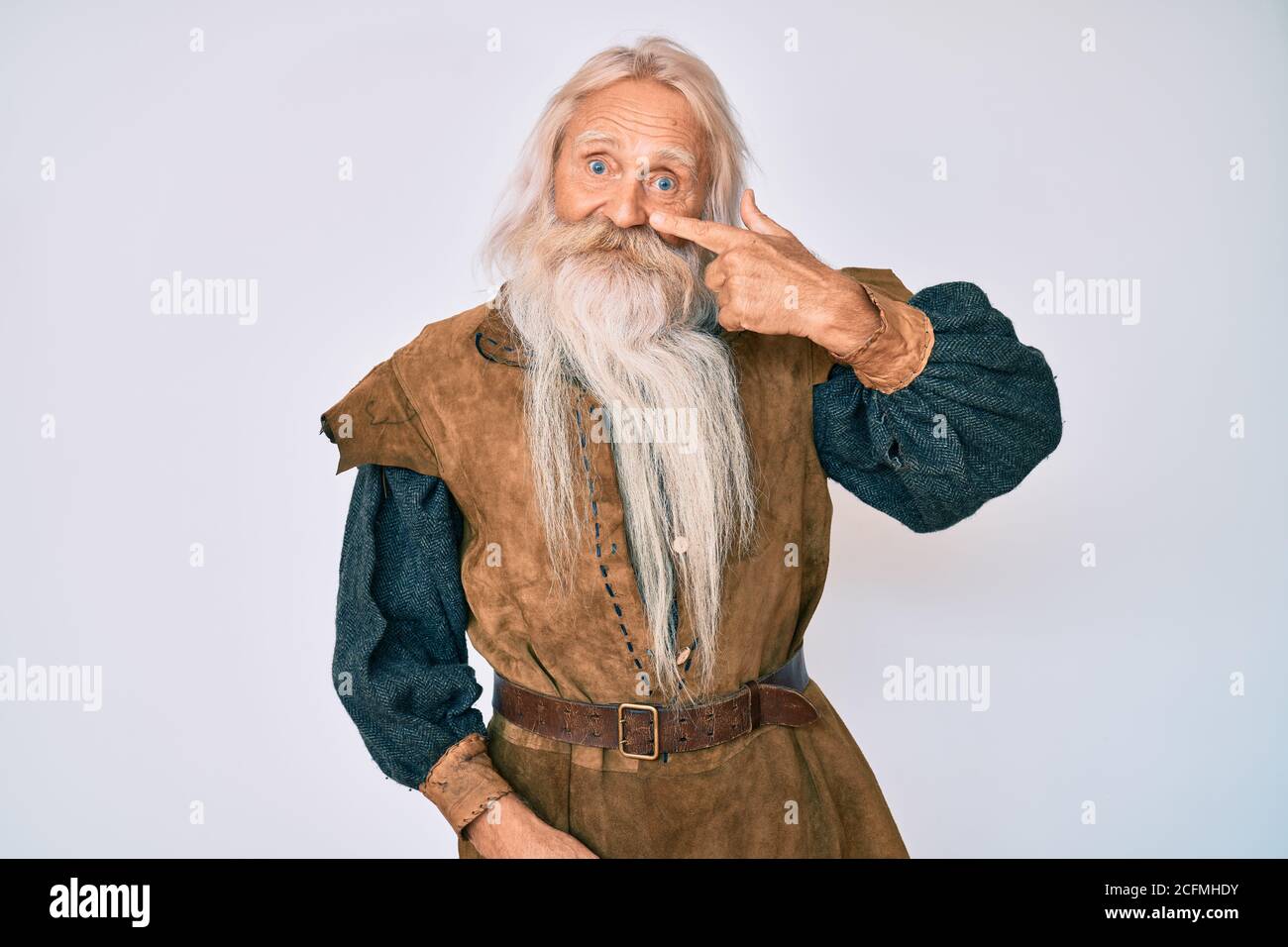 Old senior man with grey hair and long beard wearing viking traditional ...