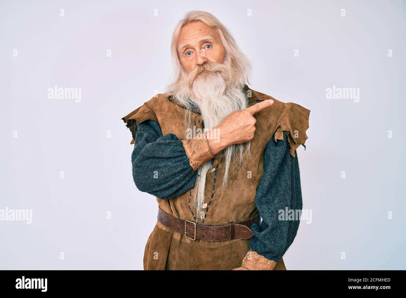 Old senior man with grey hair and long beard wearing viking traditional ...