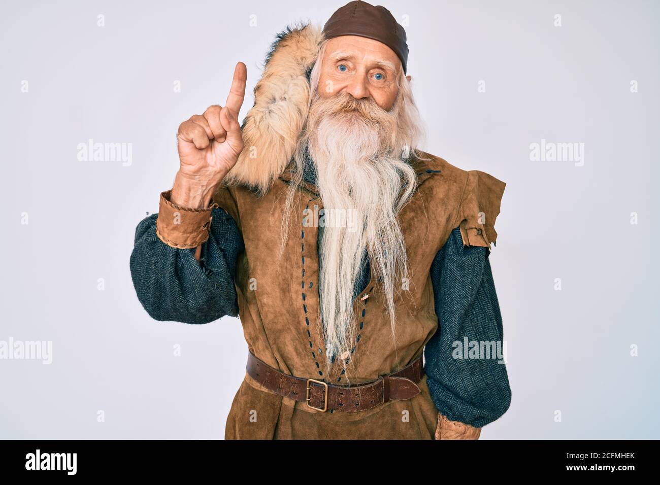 Old senior man with grey hair and long beard wearing viking traditional ...