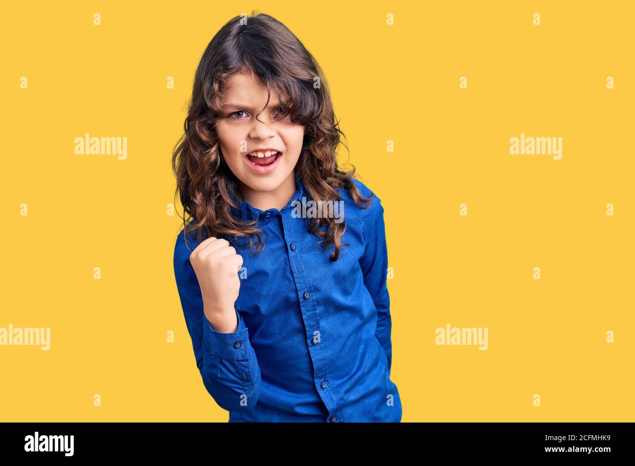 Cute child with long hair wearing casual clothes angry and mad raising ...