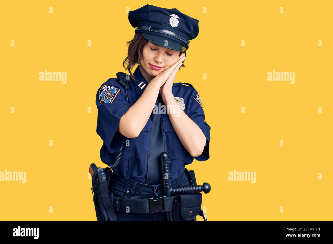 Young beautiful girl wearing police uniform sleeping tired dreaming and ...