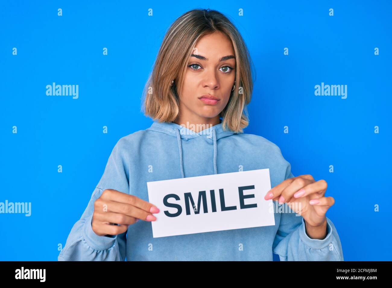 Beautiful caucasian woman holding smile text clueless and confused ...