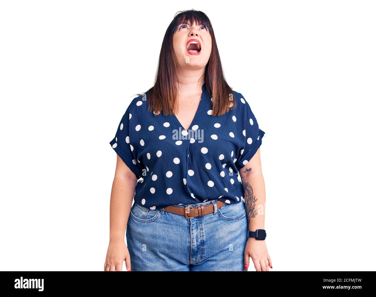 Young plus size woman wearing casual clothes angry and mad screaming ...