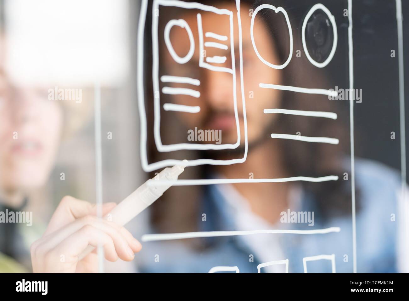 Hand of young female developer of mobile application drawing with tip ...