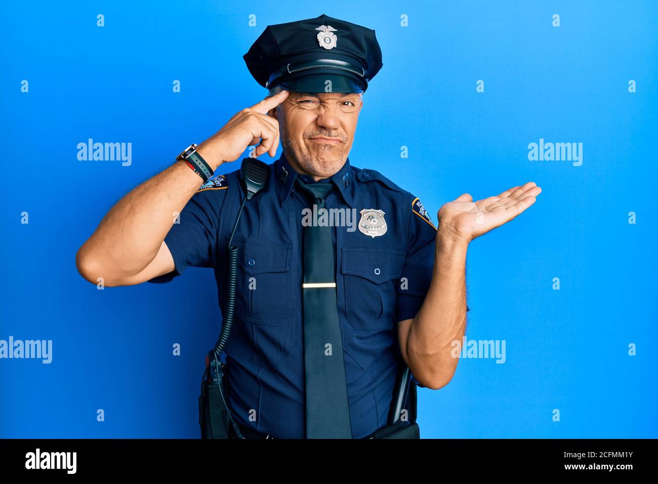 Handsome middle age mature man wearing police uniform confused and ...