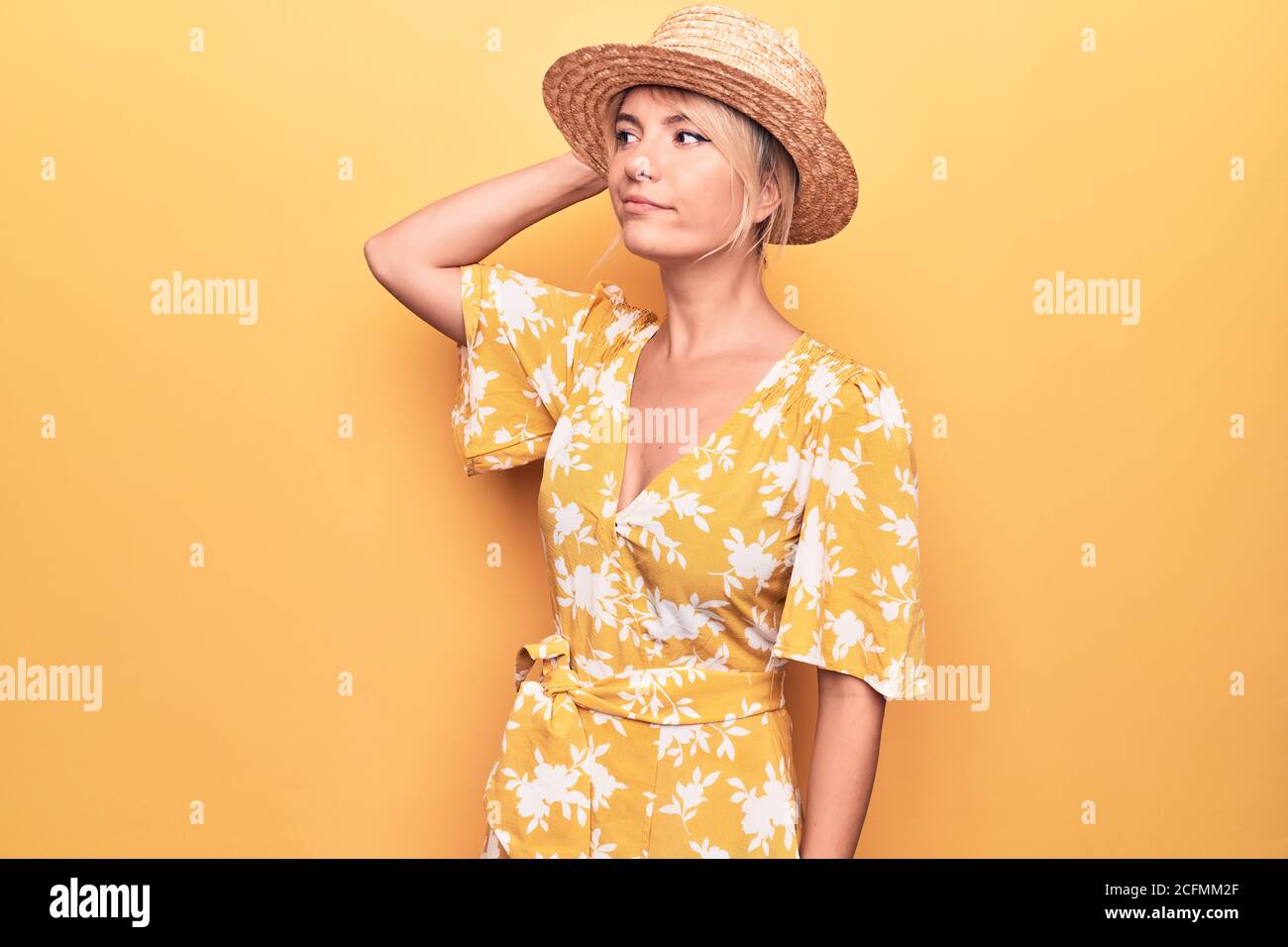 Beautiful blonde woman on vacation wearing summer hat and dress over ...