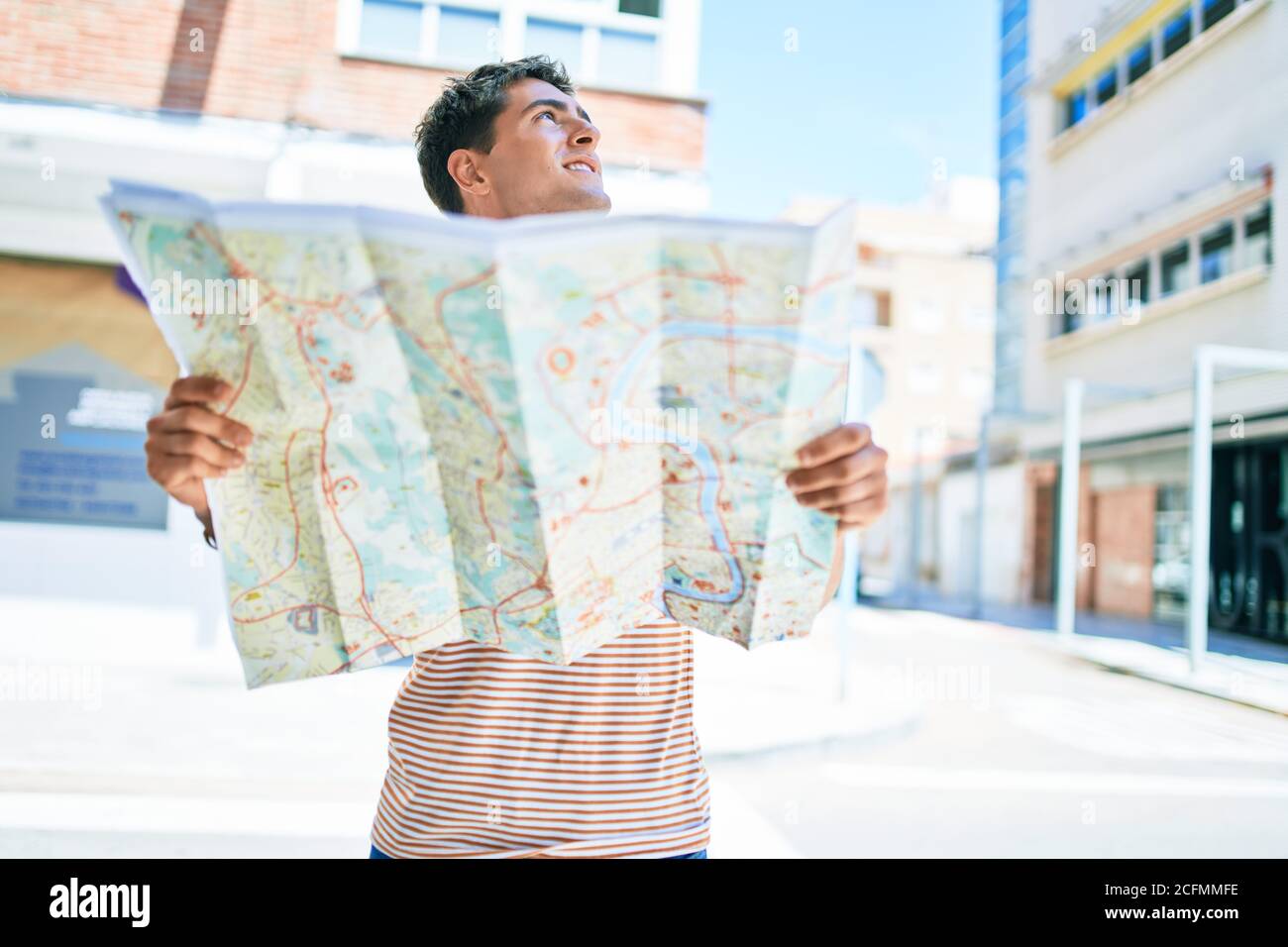 Young handsome caucasian tourist man looking city map at street Stock ...