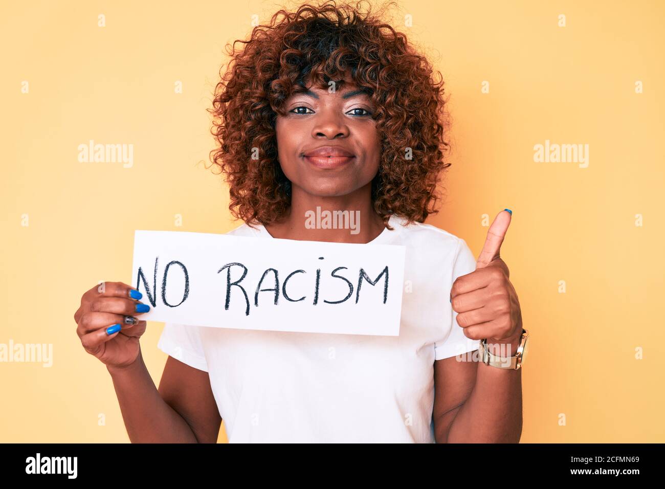 Young african american woman holding no racism banner smiling happy and ...