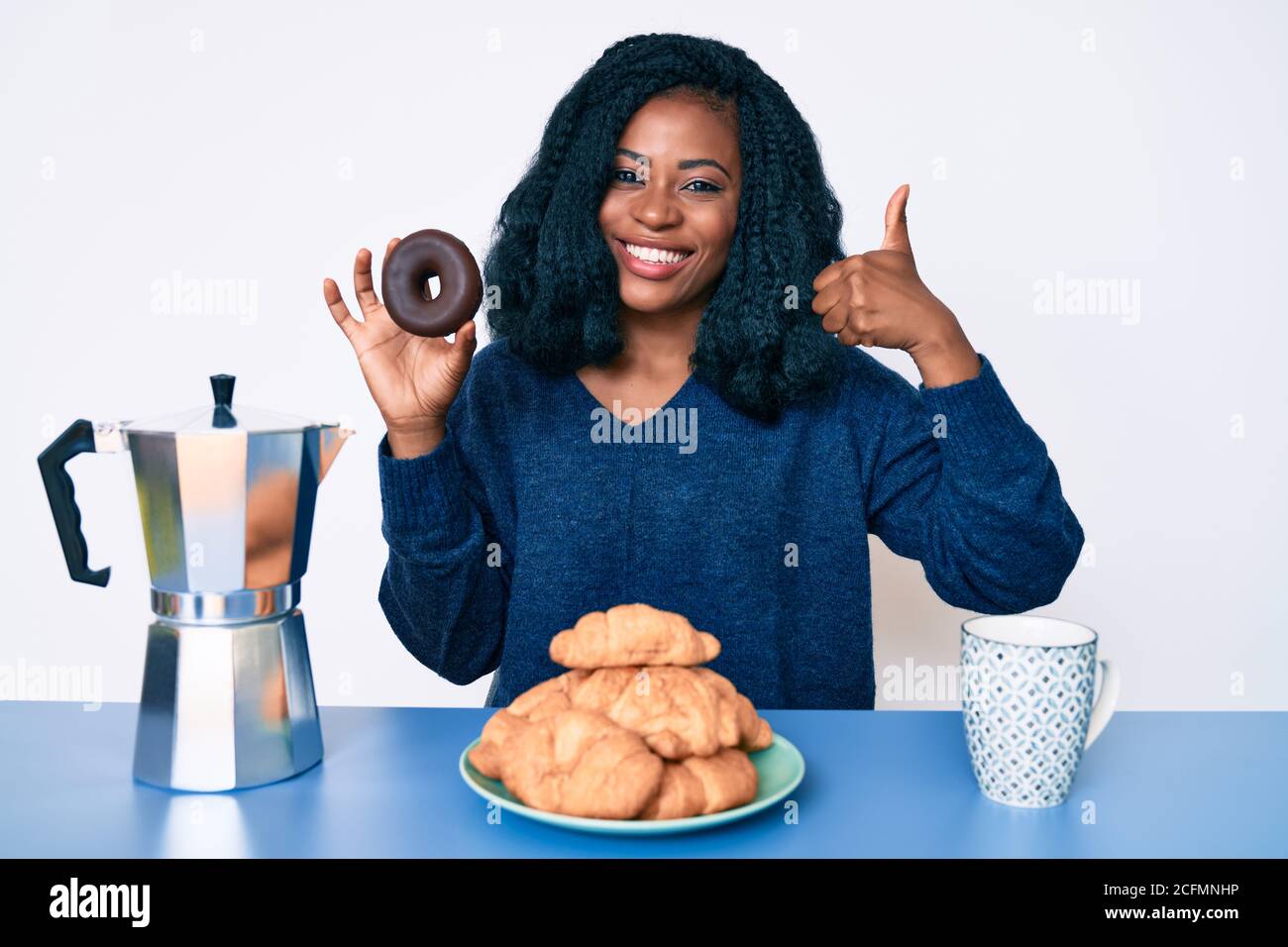 Beautiful African Woman Eating Breakfast Holding Cholate Donut Smiling