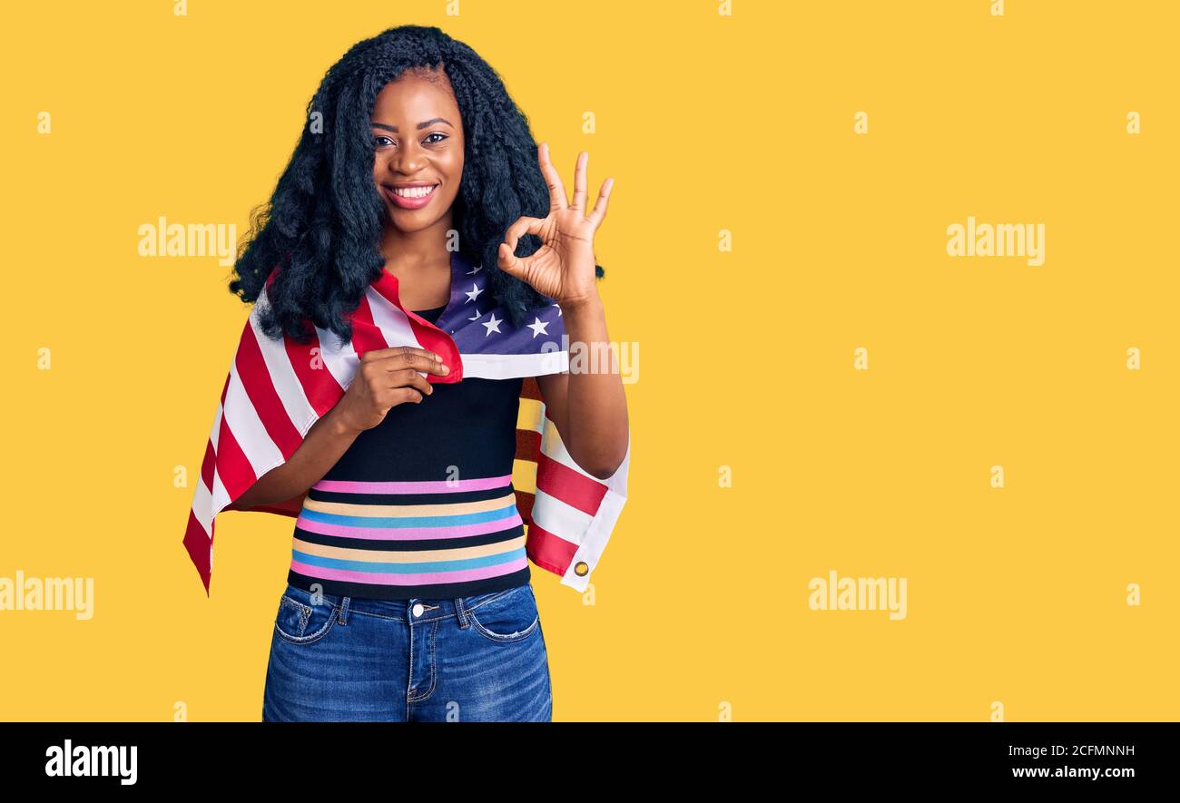 Beautiful african american woman holding united states flag doing ok ...