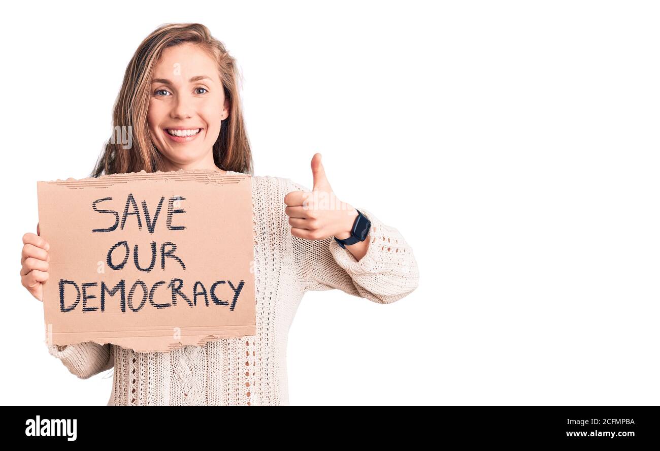 Young beautiful blonde woman holding save our democracy banner smiling ...