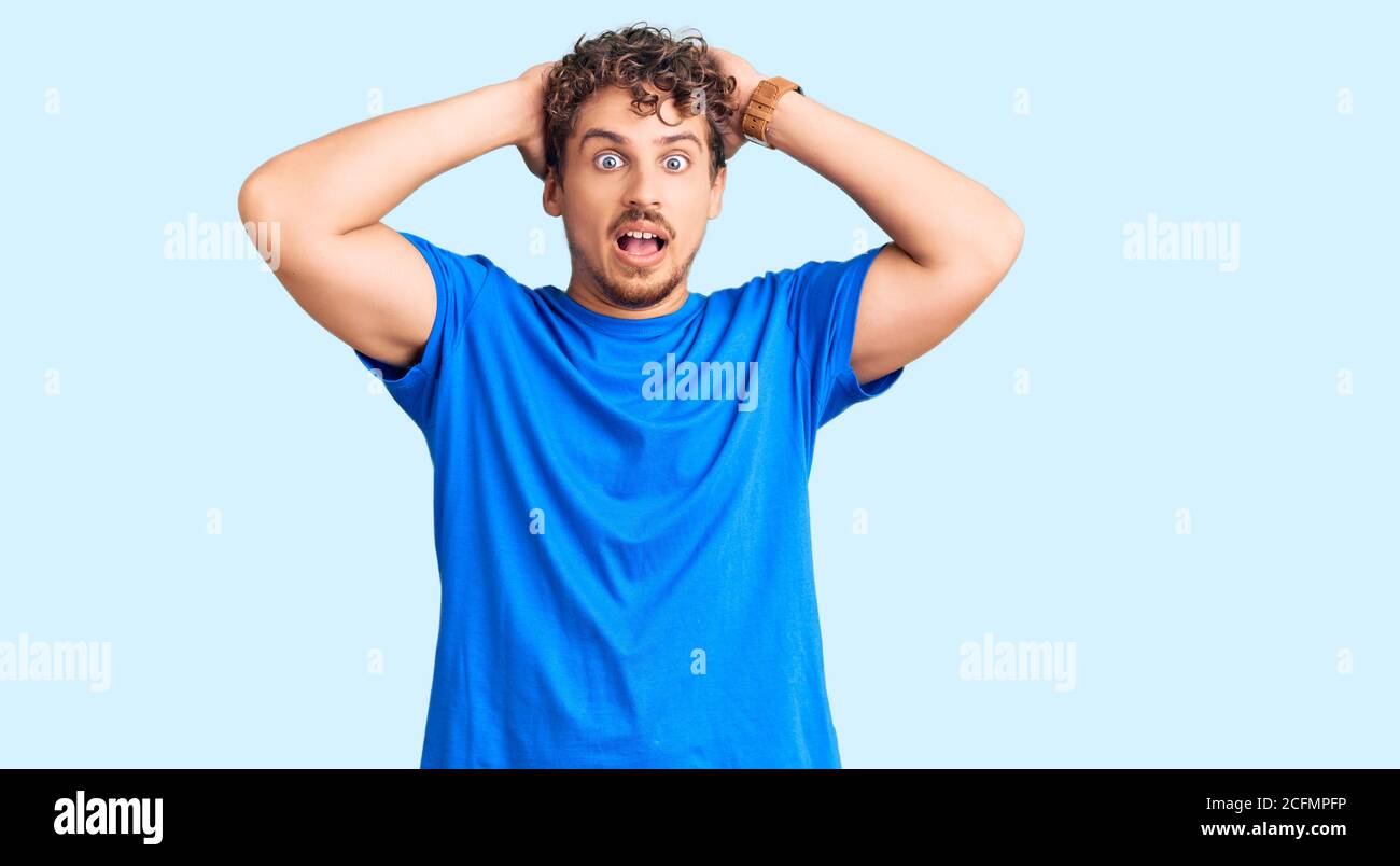 Young handsome man with curly hair wearing casual clothes crazy and ...