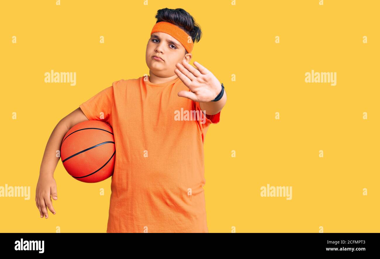 Little boy kid holding basketball ball with open hand doing stop sign ...