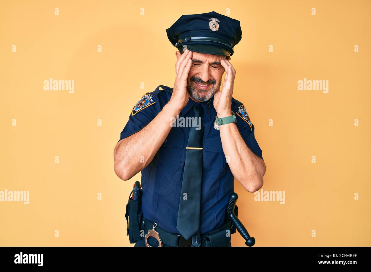 Middle age hispanic man wearing police uniform with hand on head ...