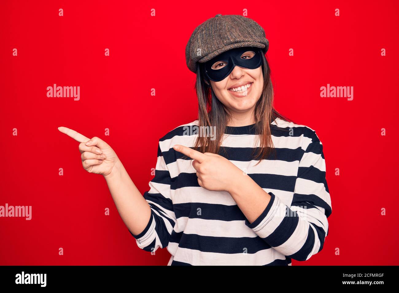 Young beautiful brunette burglar woman wearing cap and mask over ...