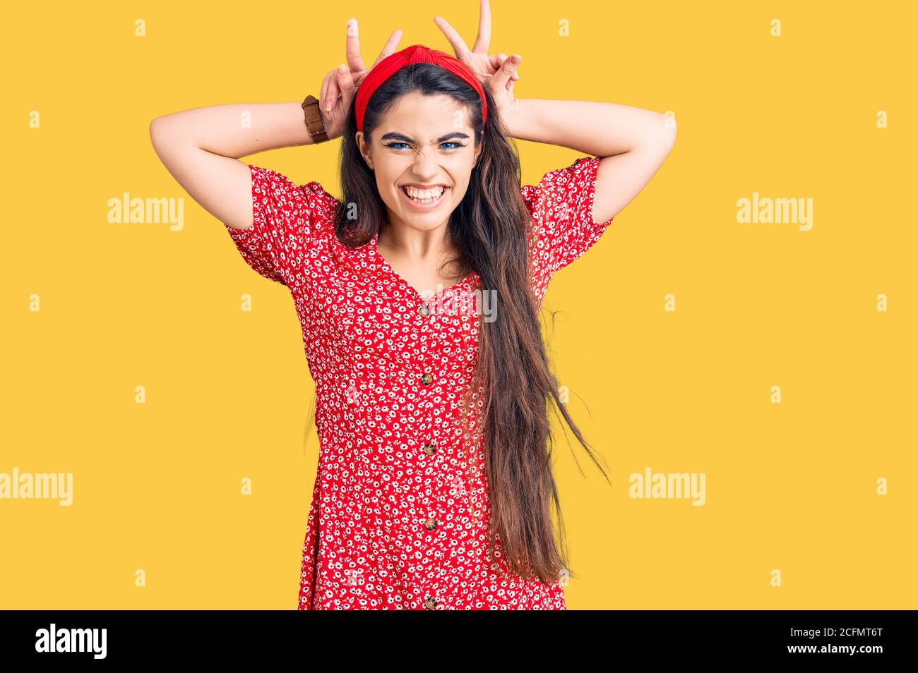 Brunette teenager girl wearing summer dress posing funny and crazy with ...