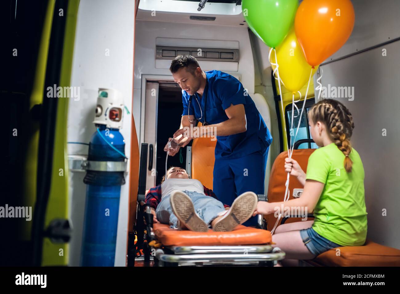 Unconscious Mother Lying On A Stretcher In An Ambulance Car A
