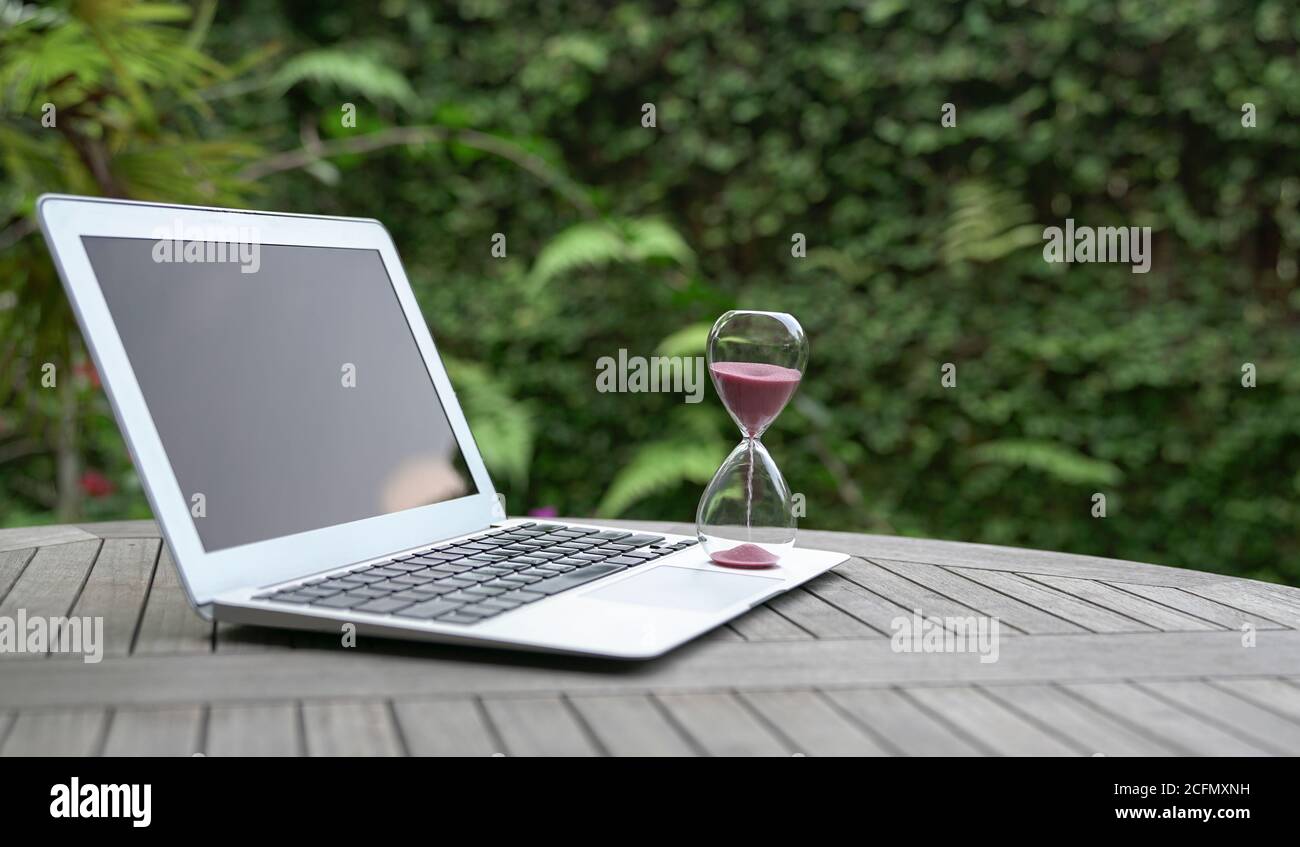 Hourglass on laptop computer. Time management, countdown and deadlines ...