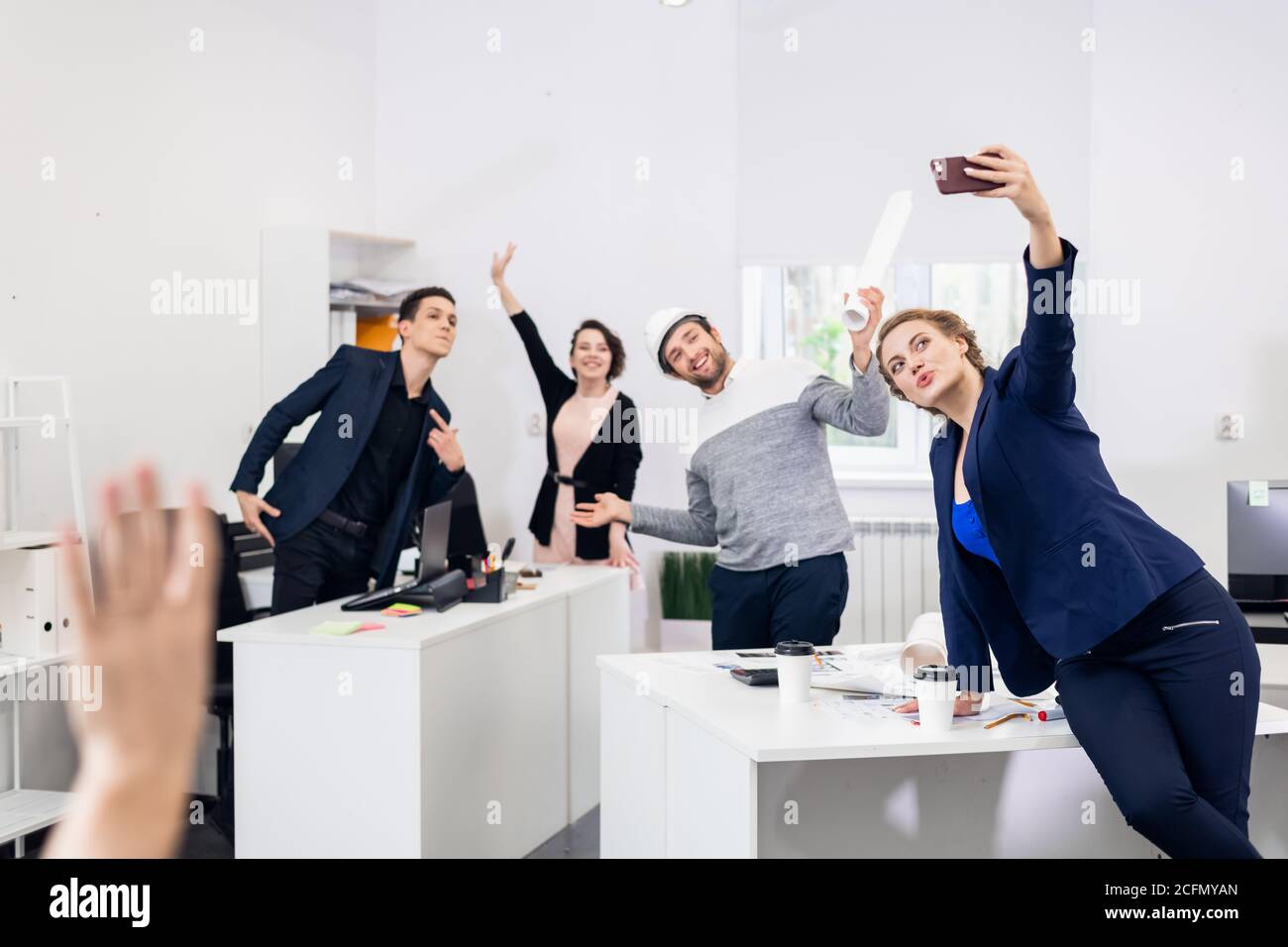 Portrait of four happy, cheerful business people celebrating a ...