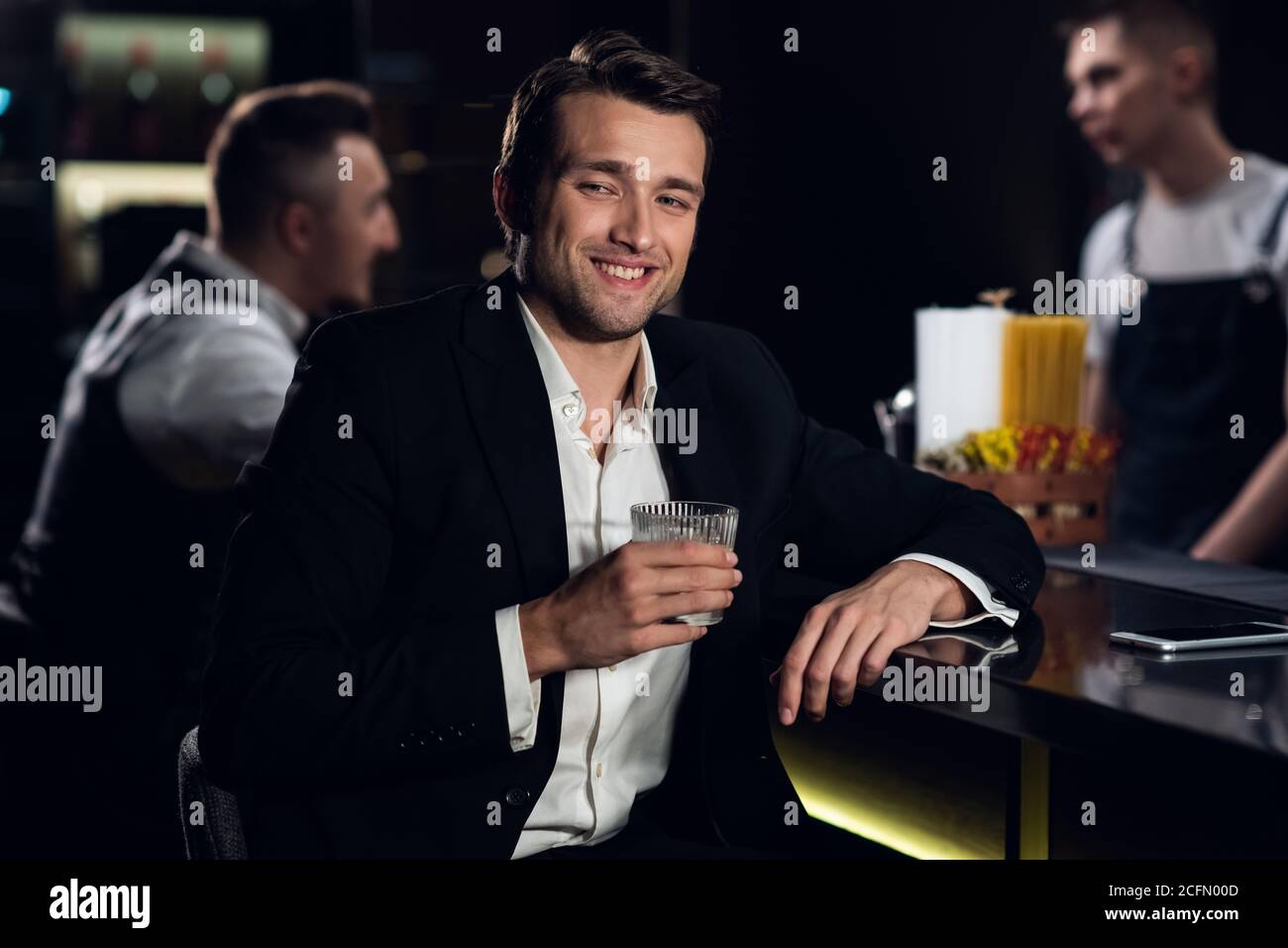 a beautiful man poses for a photo at the bar of a restaurant with a ...