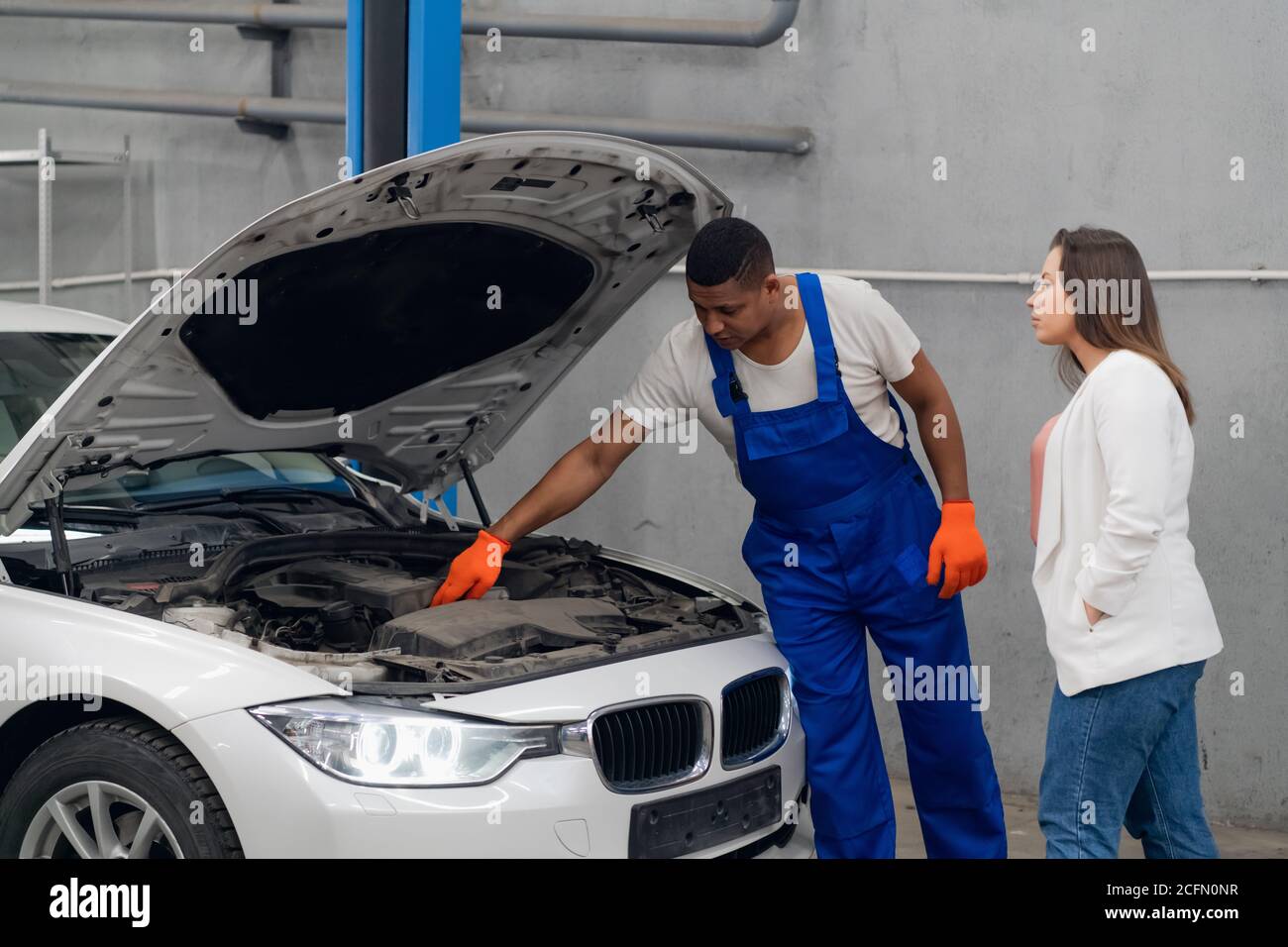 Car service worker show customer engine. Car hood open Stock Photo - Alamy