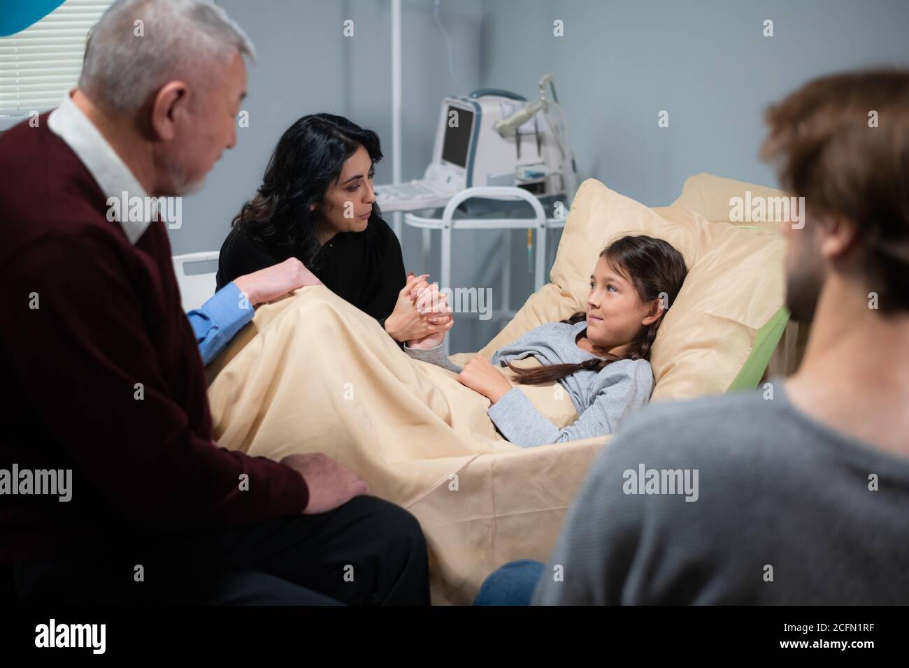 A family consoling a little girl during their visit at the hospital ...