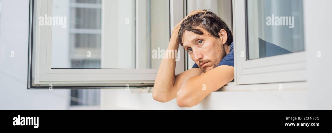 BANNER, LONG FORMAT Extremly tired young man looking out the window ...
