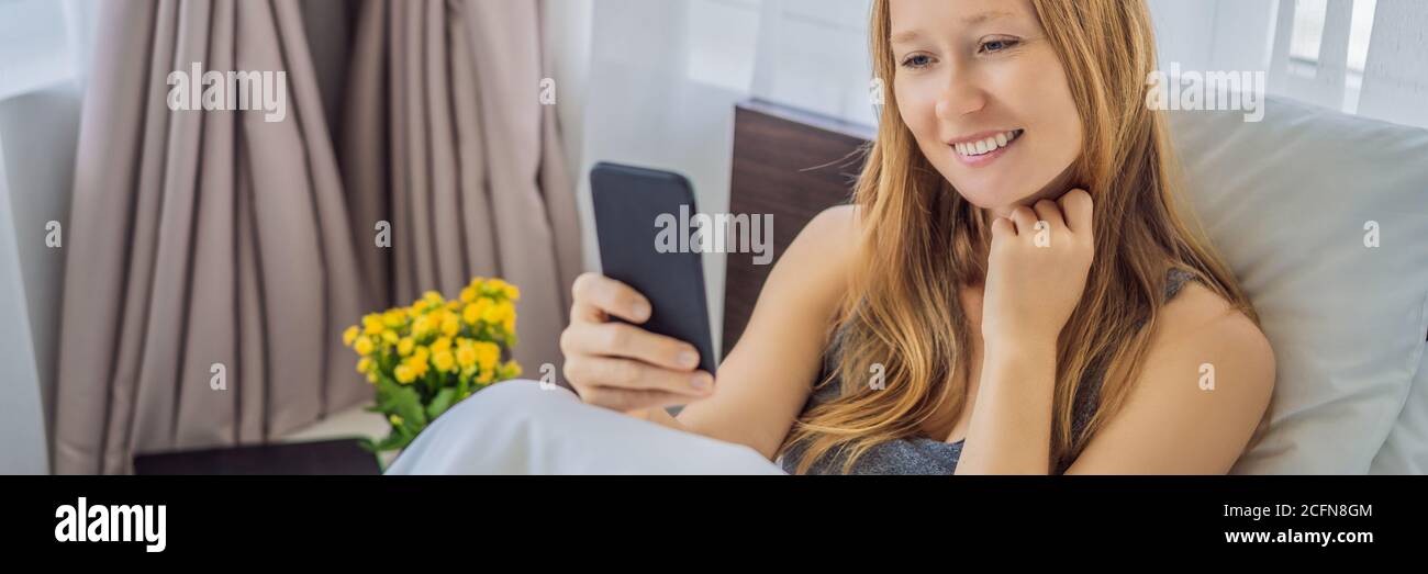 Woman talking by video call while lying in bed BANNER, LONG FORMAT ...