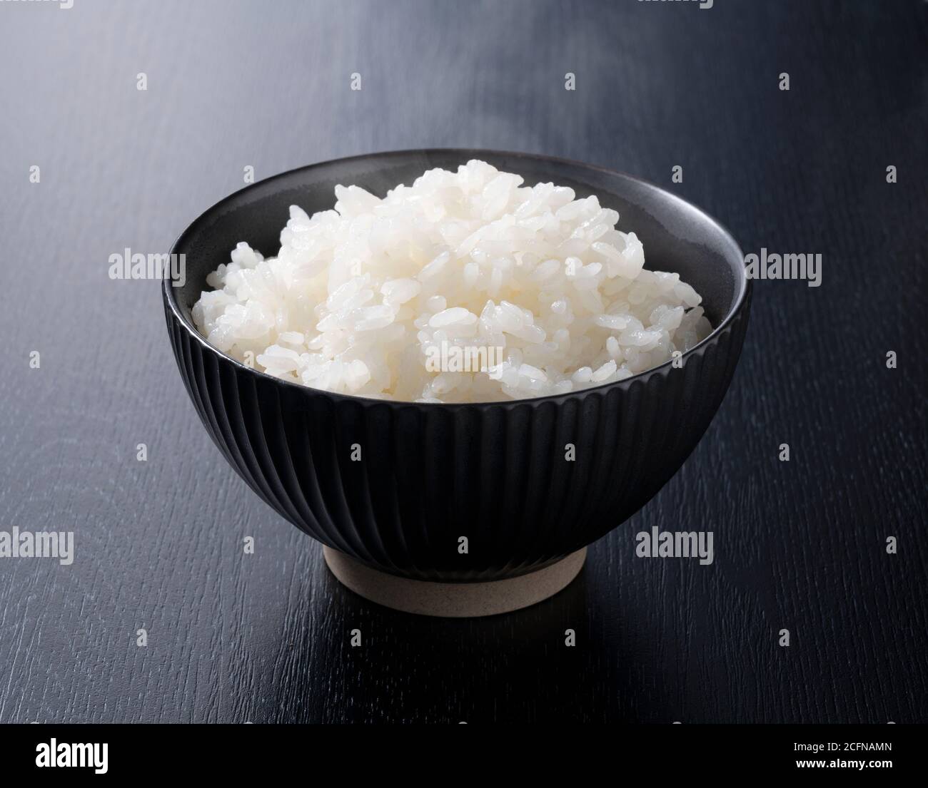 Rice on a black background, taken from an angle Stock Photo - Alamy