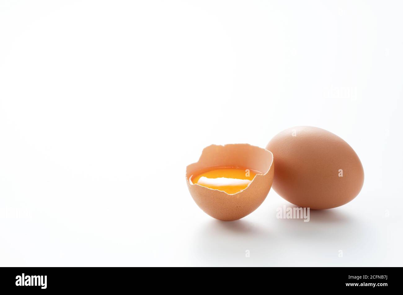 A broken egg placed on a white background with copy space was ...