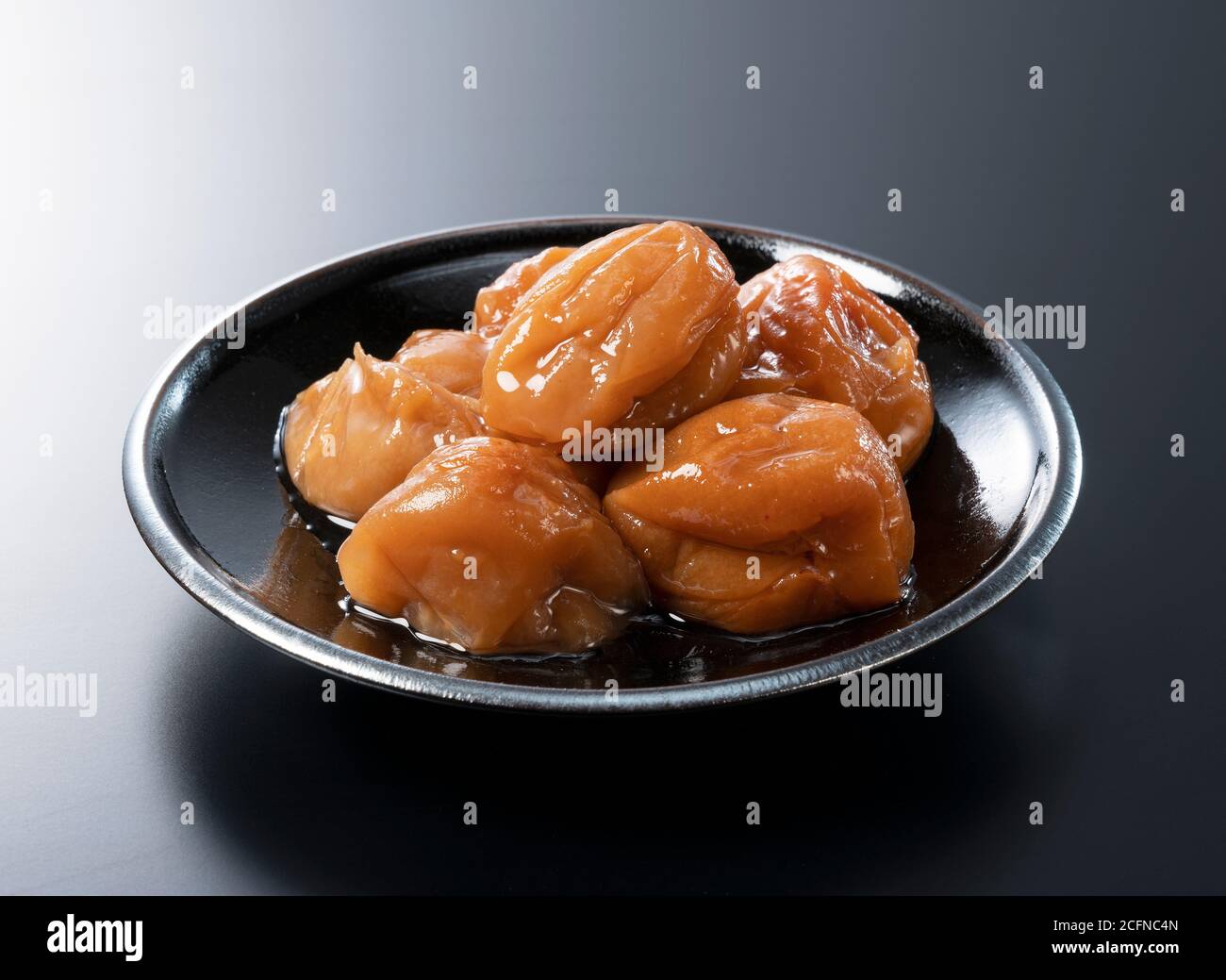 Japanese pickled plums set against a black background. (Kishu Nanko Ume ...