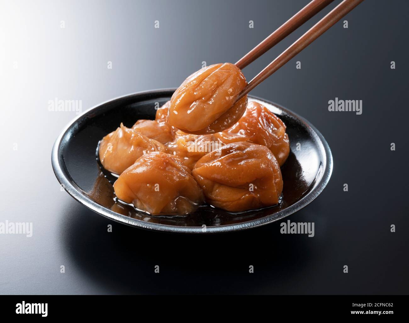 Japanese pickled plums set against a black background. I'll hold it up ...