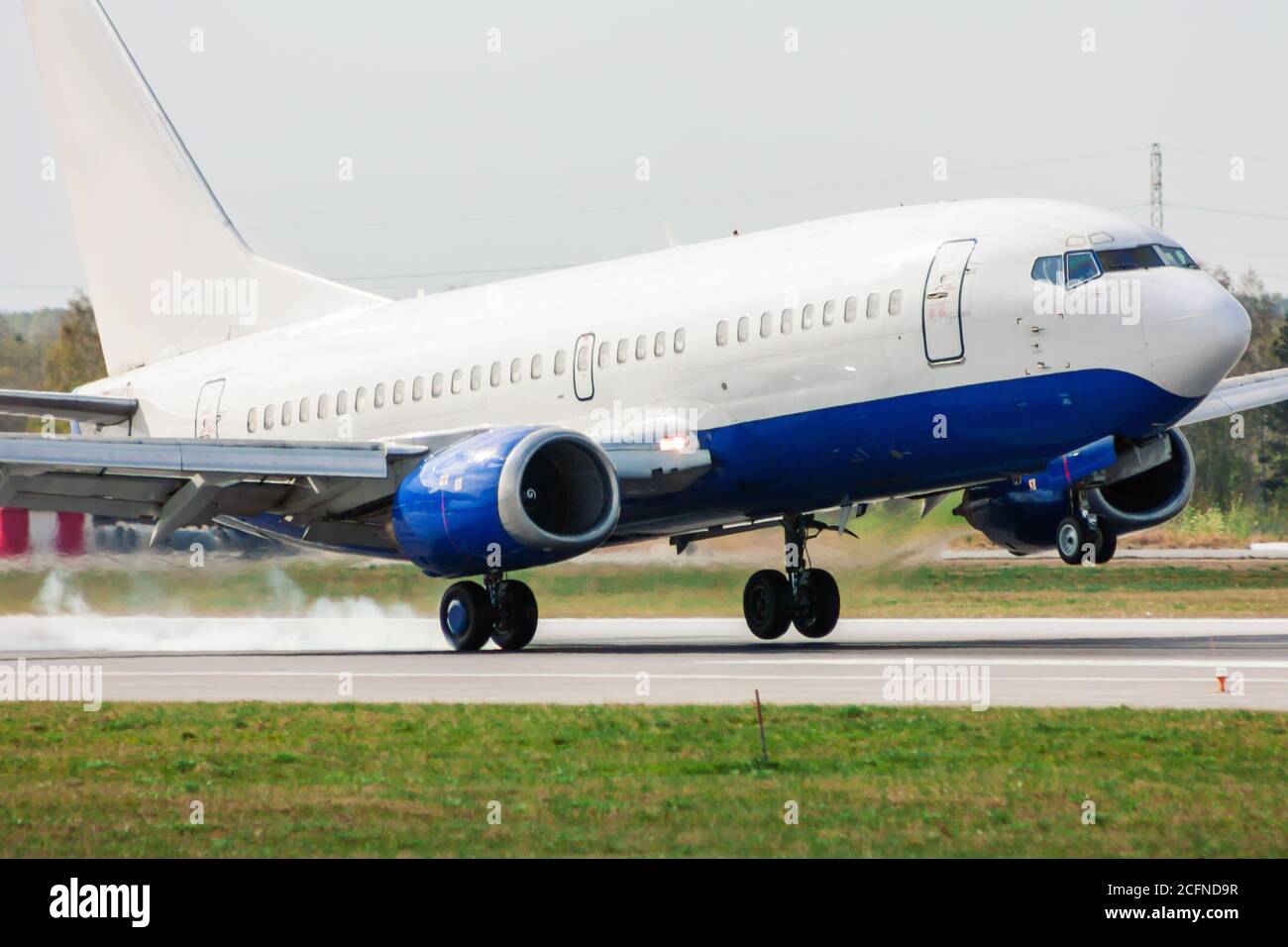 Airplane landing on runway. Touchdown with tire smoke Stock Photo - Alamy
