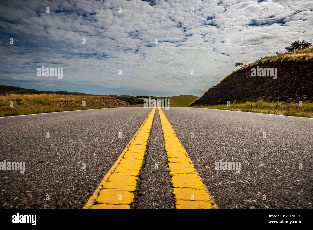 Perspective view of yellow lane lines of an old asphalt road through ...