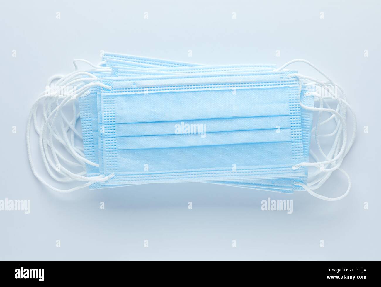 Pile of disposable medical face masks on blue background. Personal ...