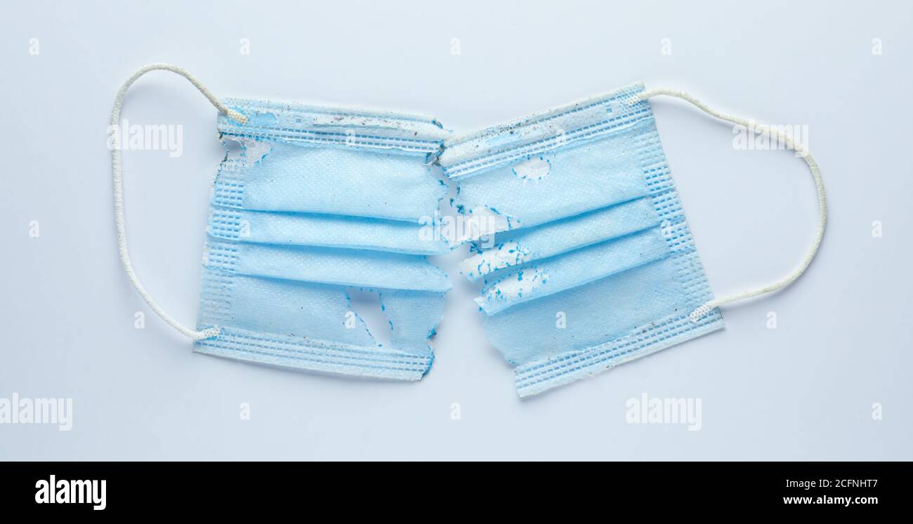 Used, broken, and torn medical face mask. Showing dangerous lack of ppe ...