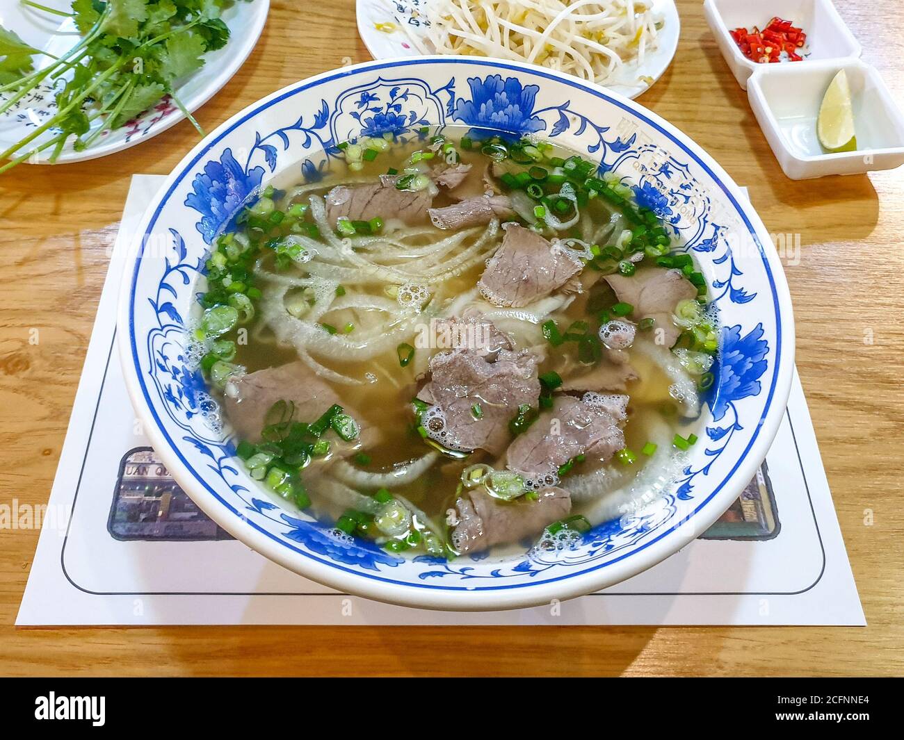 Pho Bo, a Vietnamese soup consisting of broth, rice noodles, herbs, and ...