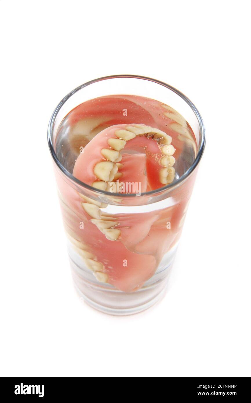 teeth prosthesis in the glass isolated on the white background Stock ...