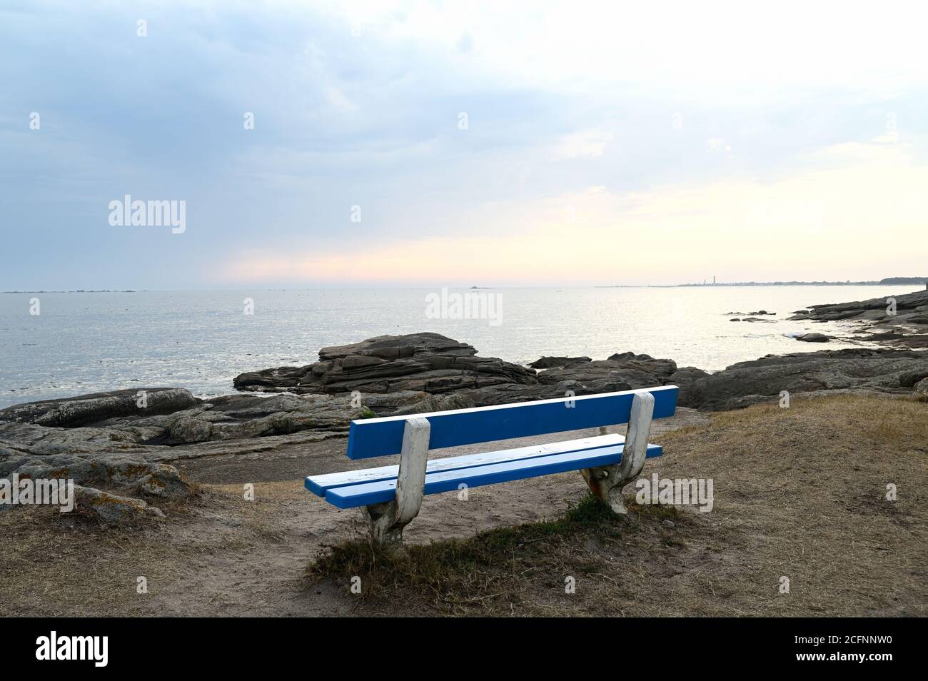 An empty blue bench facing the atlantic ocean in french Brittany Stock ...