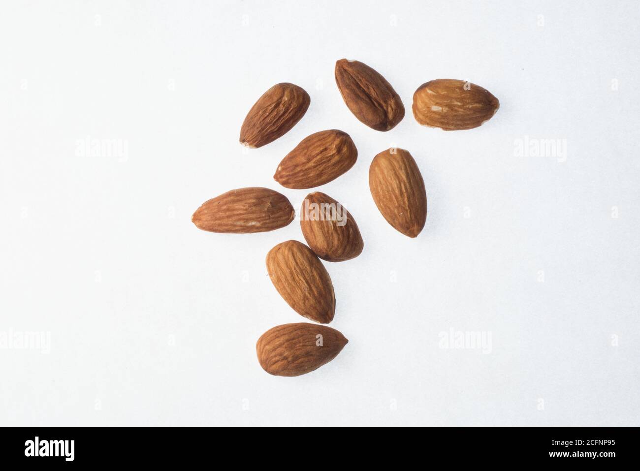 A handful of almonds scattered on a white background Stock Photo - Alamy