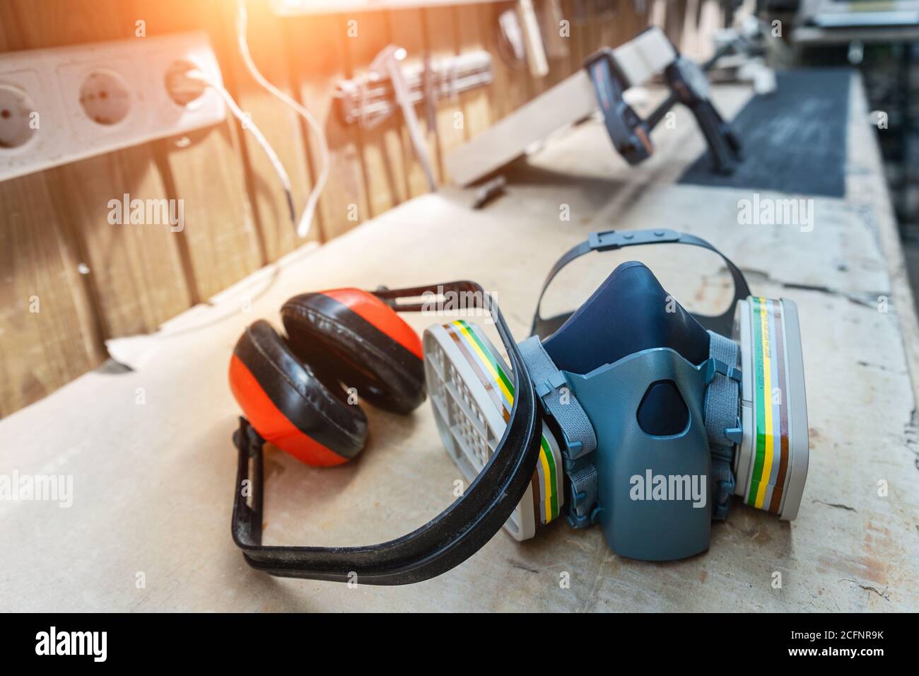 PPE respirator face half mask and ear protection equipment on wooden ...
