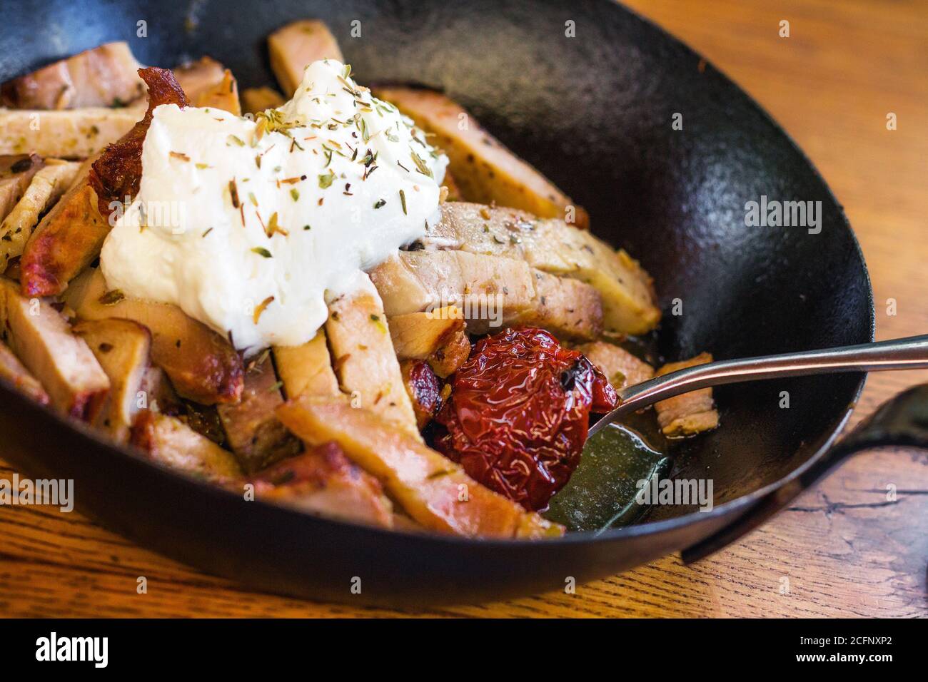 Traditional Cretan fried apaki (smoked pork) with sour cheese, herbs ...