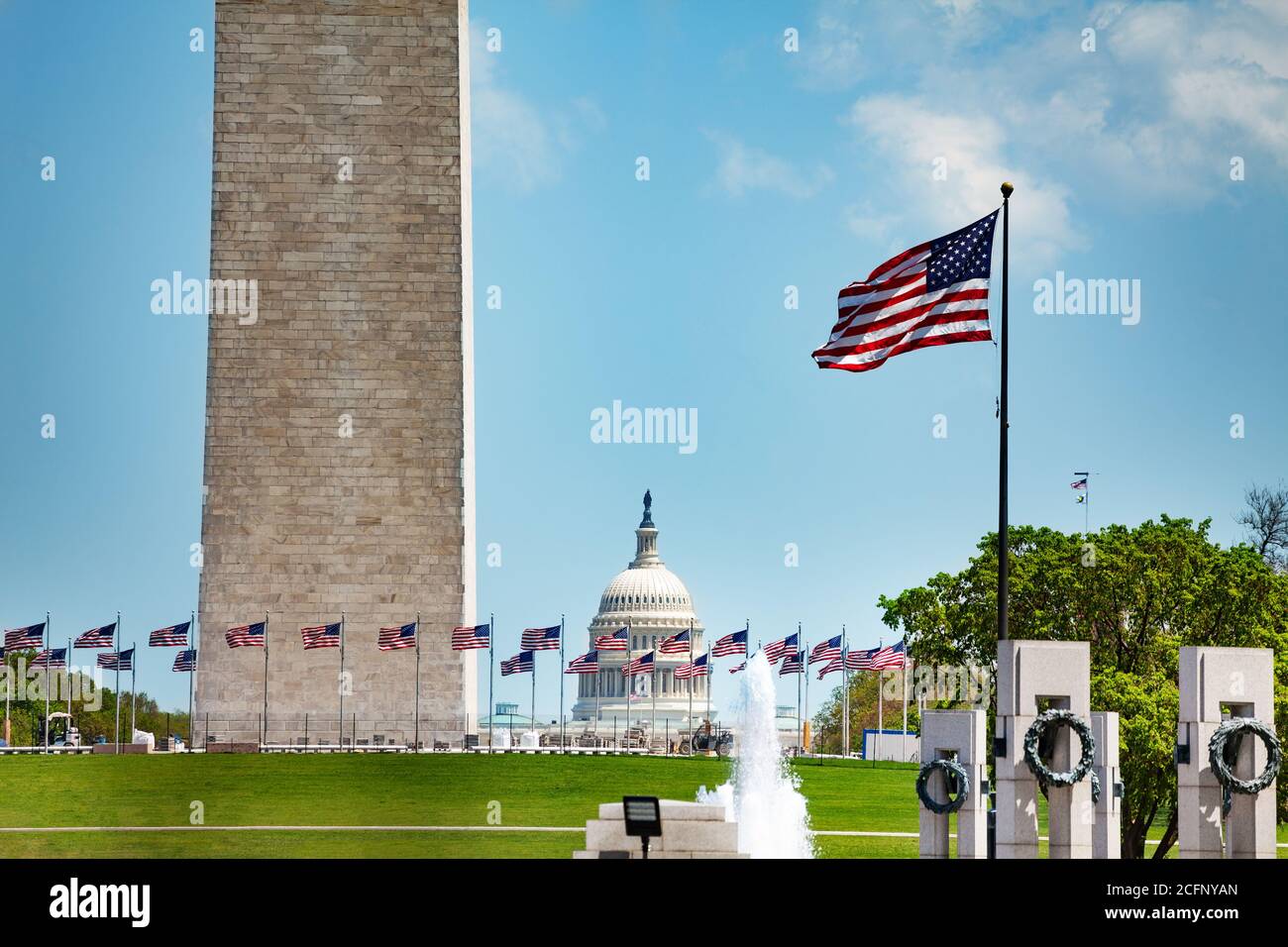 WWII and Washington memorial obelisk column over flags, US Capitol ...